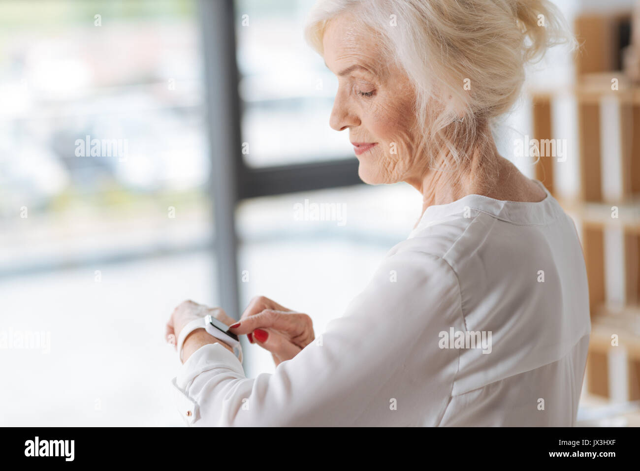 Joyful positive woman using a smartwatch Stock Photo - Alamy