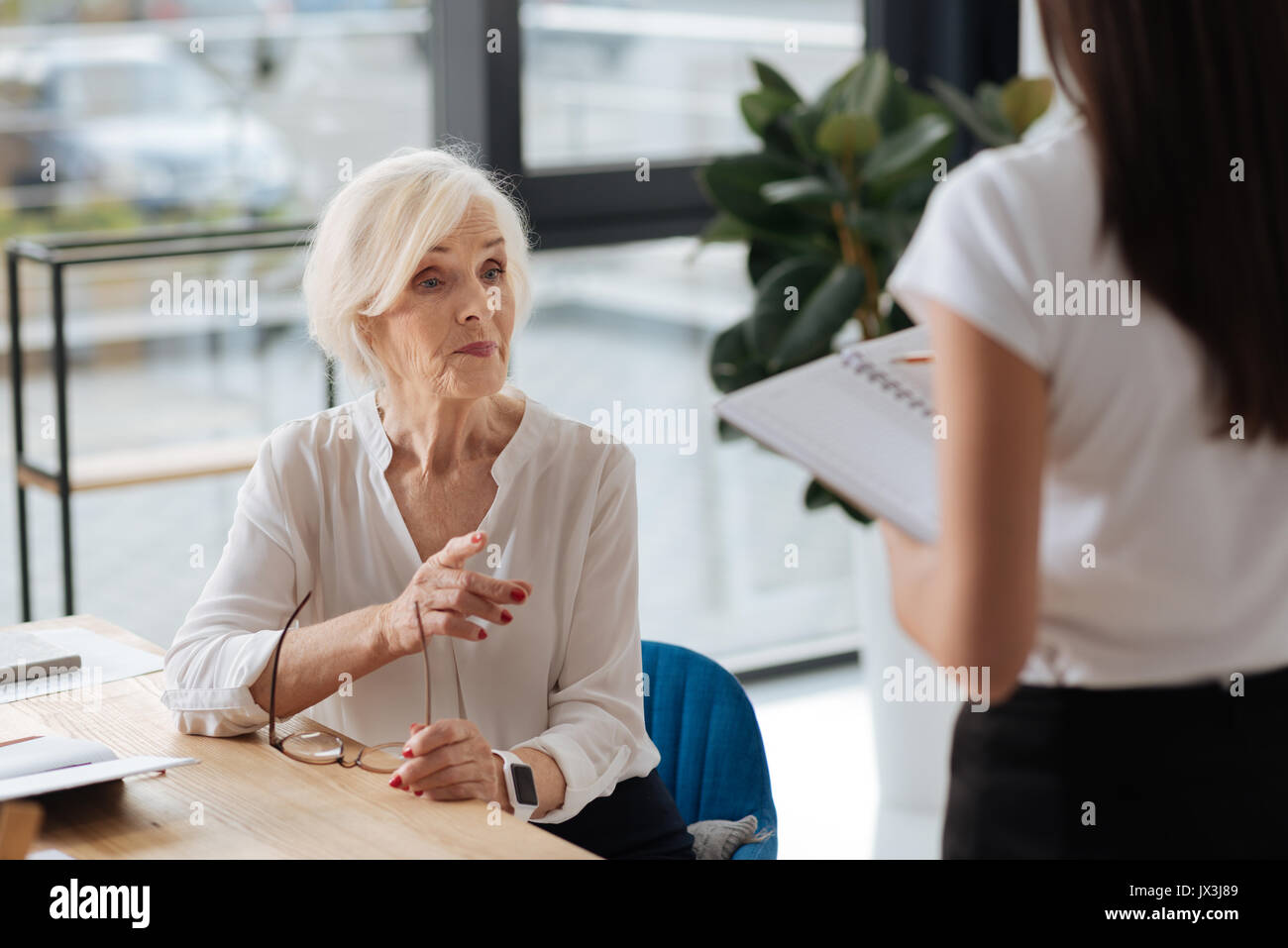 Nice experienced businesswoman giving instruction Stock Photo - Alamy