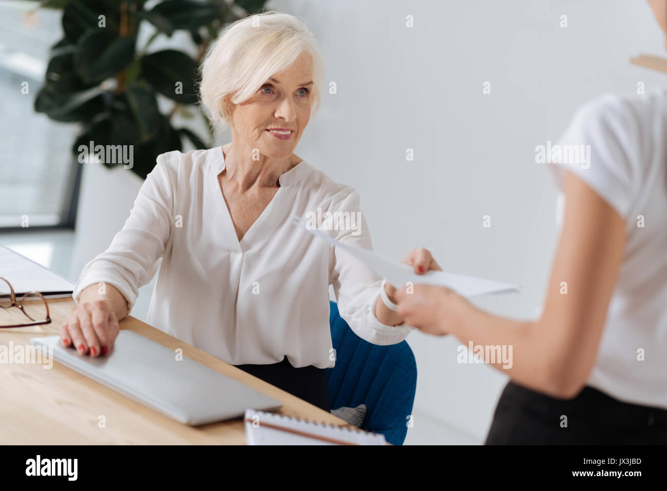 Smart elderly woman taking documents Stock Photo - Alamy
