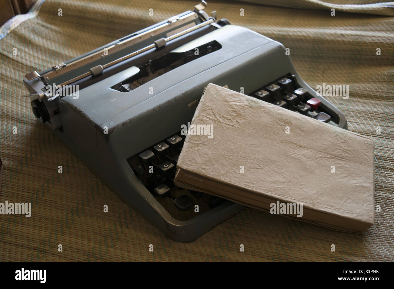 ancient typewriter and old book on a wicker mat background Stock Photo ...