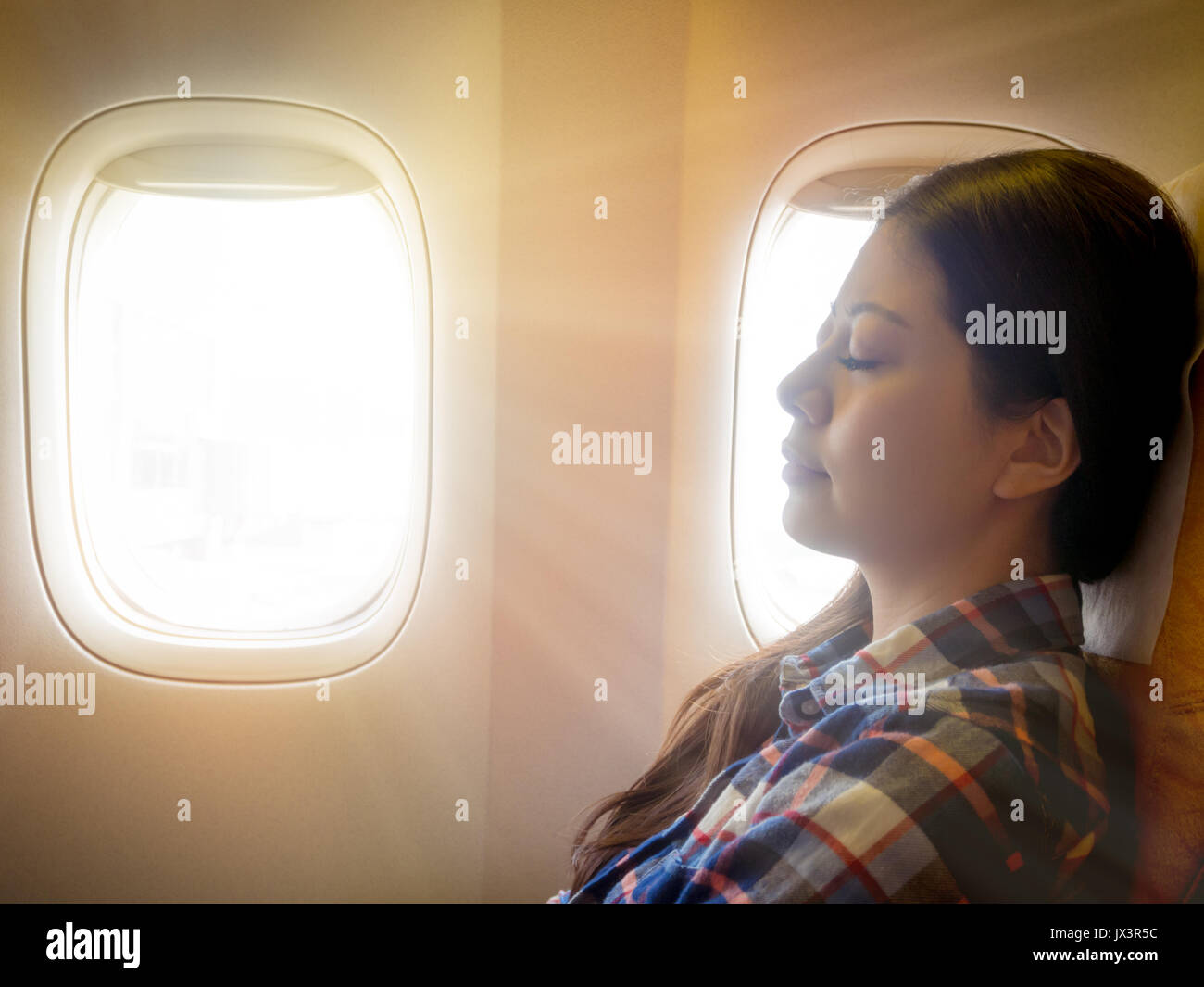 tired brunette casual asian lady napping on comfortable cabin seat ...