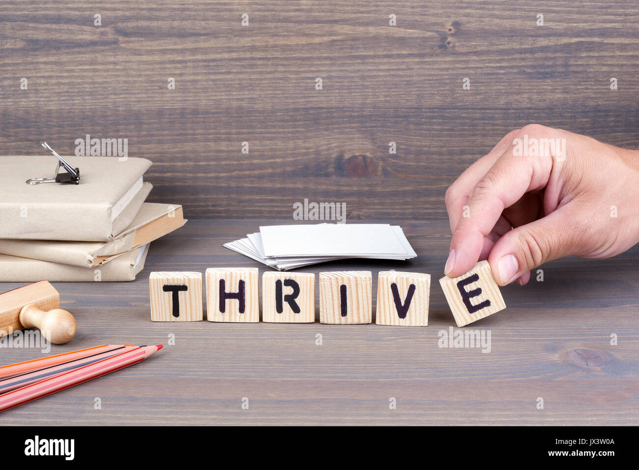 thrive concept.Wooden letters on dark background. Office desk Stock ...