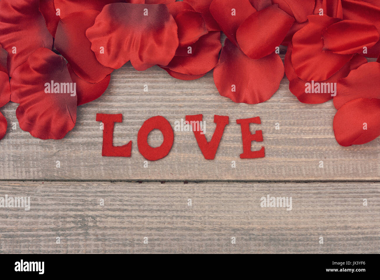 Rose petals above the love writing Stock Photo - Alamy