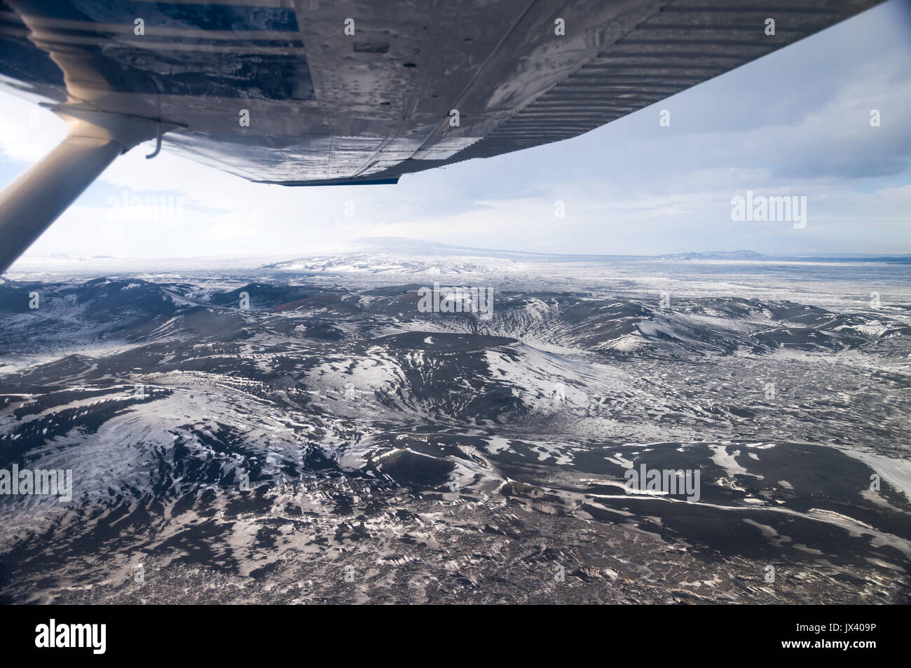 Aerial view from plane interior of Iceland snow and ice capped ...