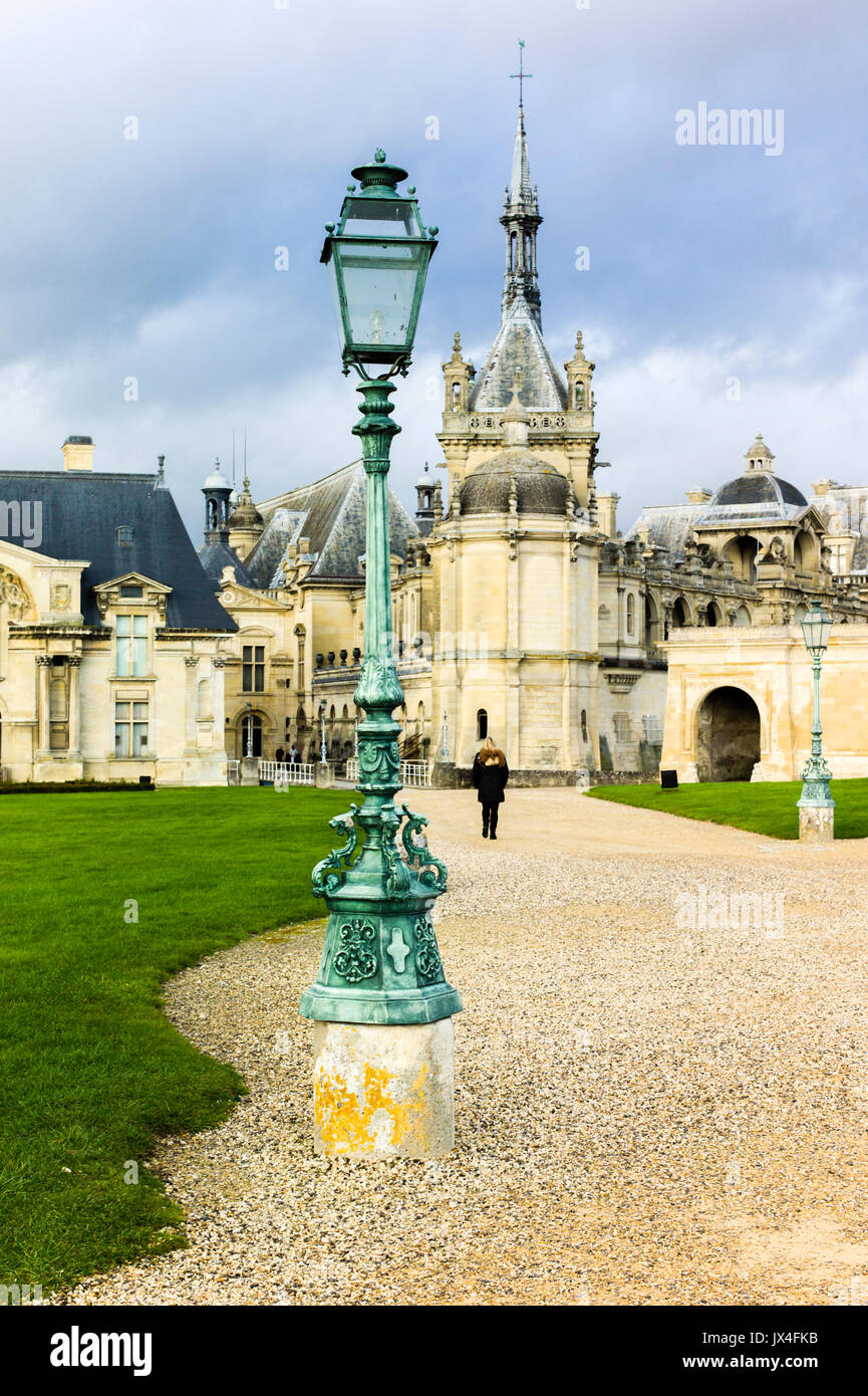 Lamp post and Palace of Chantilly in golden afternoon light Stock Photo ...