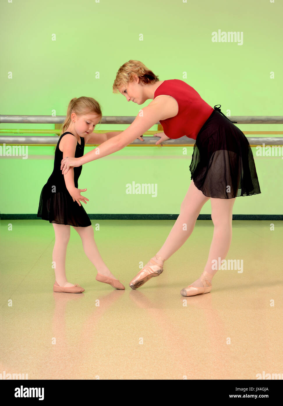 A Ballet Teacher Helps a Girl Dance Student with her lesson Stock Photo ...