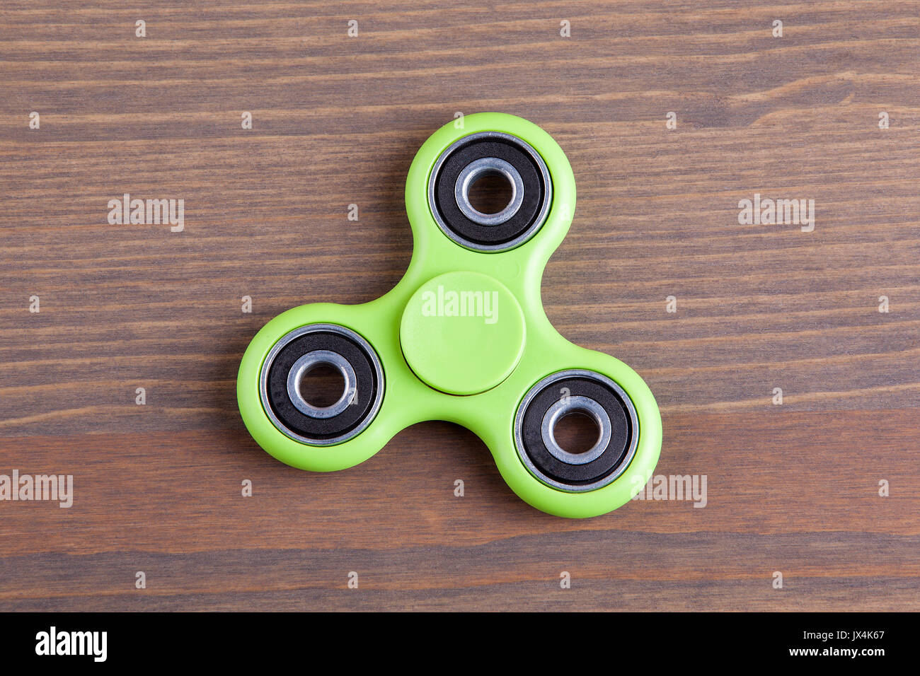 Green fidget spinner stress relieving toy on wood background Stock ...