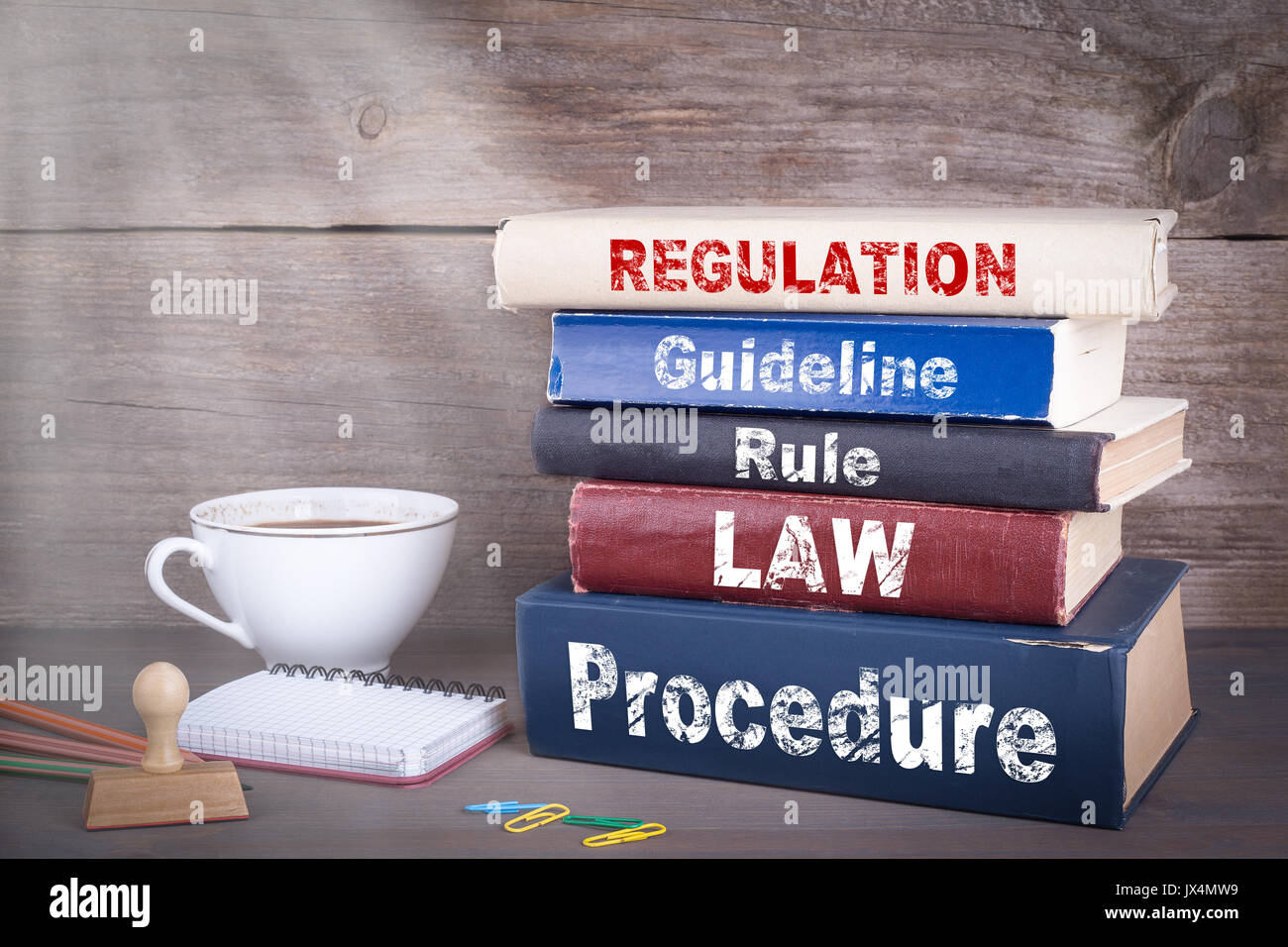 Regulation concept. Stack of books on wooden desk Stock Photo - Alamy