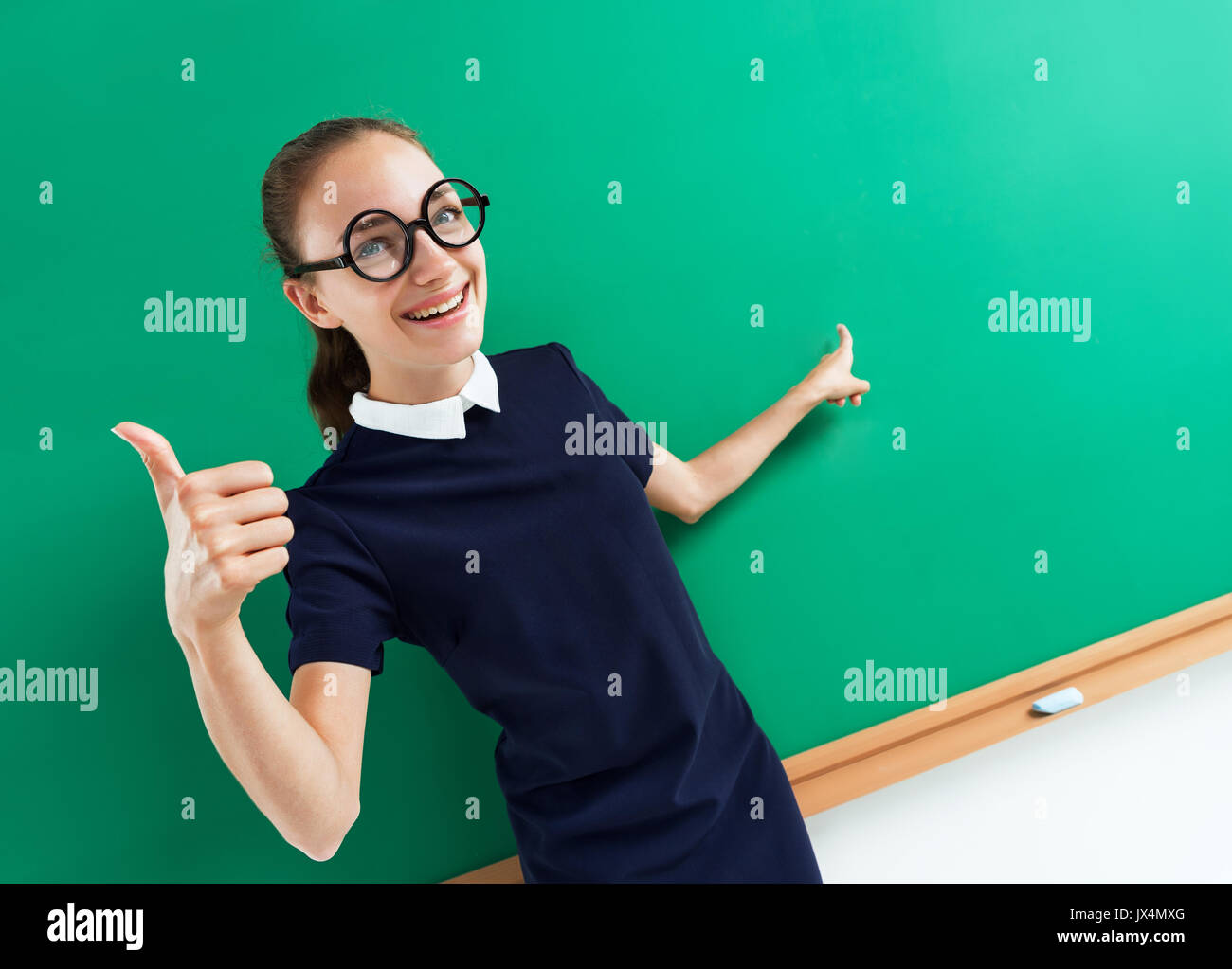 Happy student showing her thumb up and points to something. Photo of ...