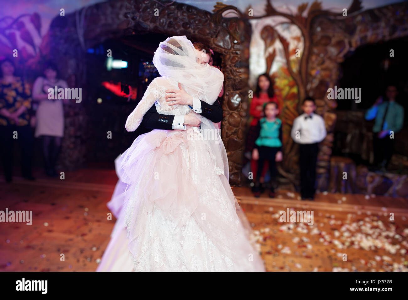Wedding couple dancing their first dance in the restaurant with ...