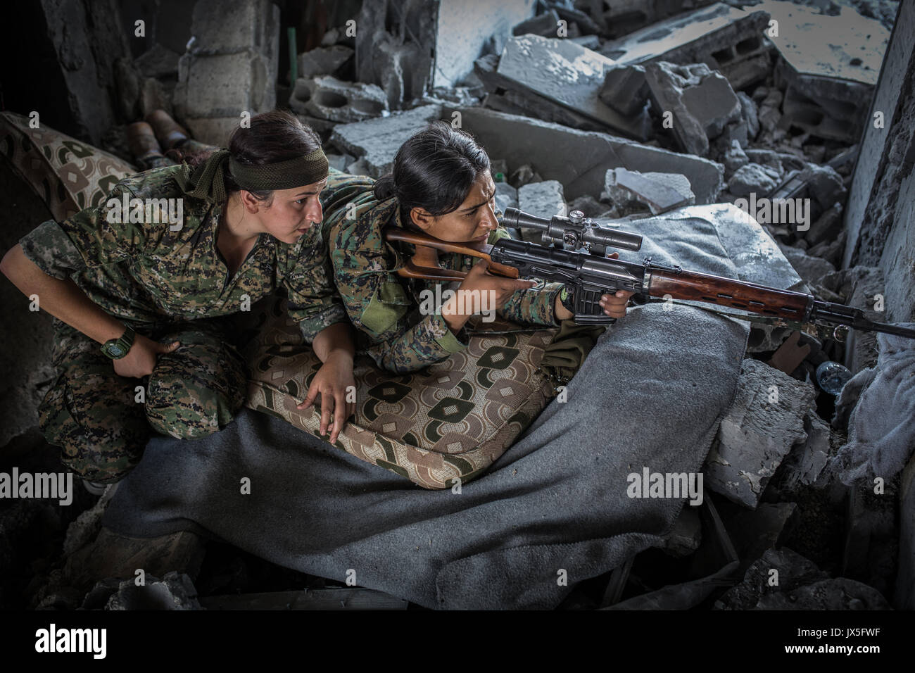 Two soldiers of the Women's Protection Units (YPJ) sighting targets ...