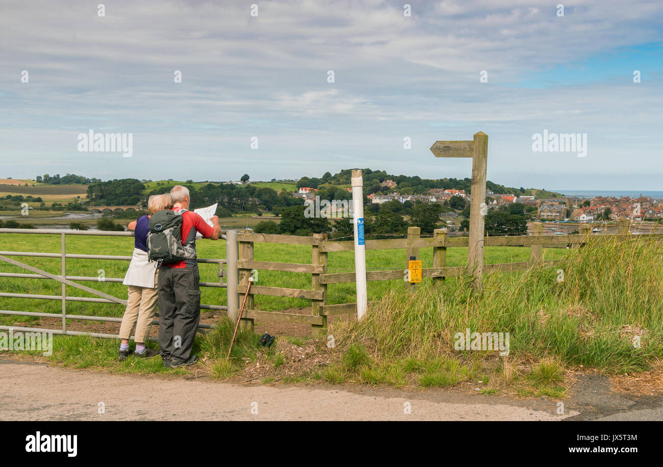 Walkers checking map on the Northumberland Coastal Path overlooking ...