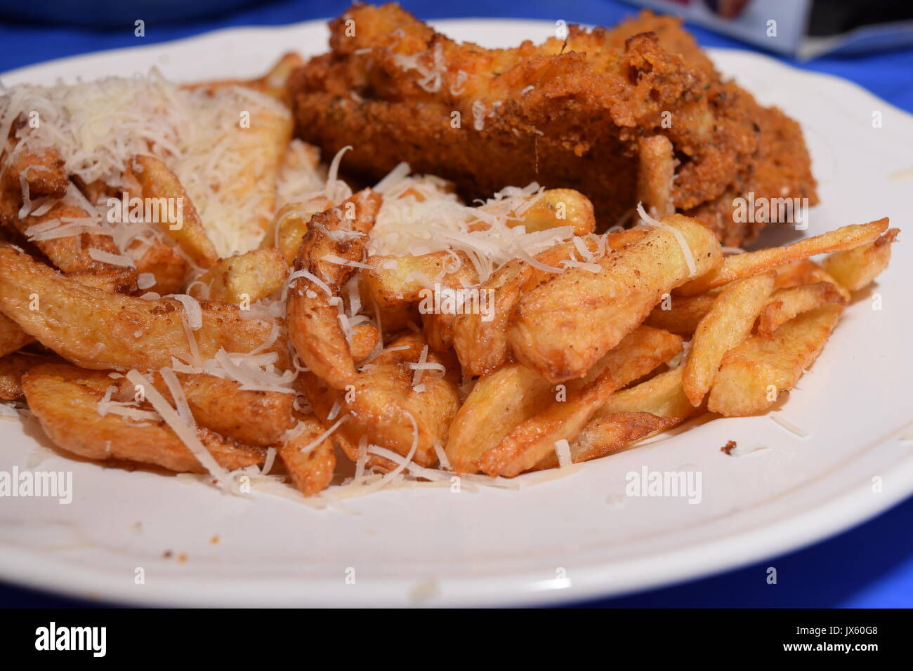 Battered fish and cheesy chips on a plate Stock Photo - Alamy