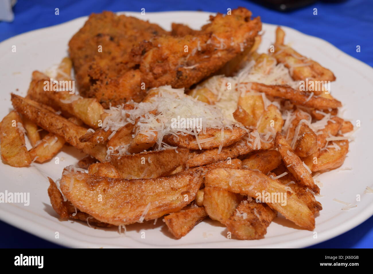 Battered fish and cheesy chips on a plate Stock Photo - Alamy