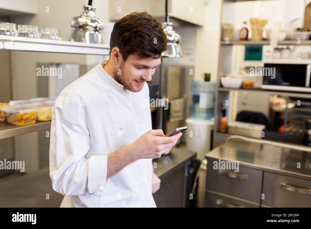 chef cook with smartphone at restaurant kitchen Stock Photo - Alamy