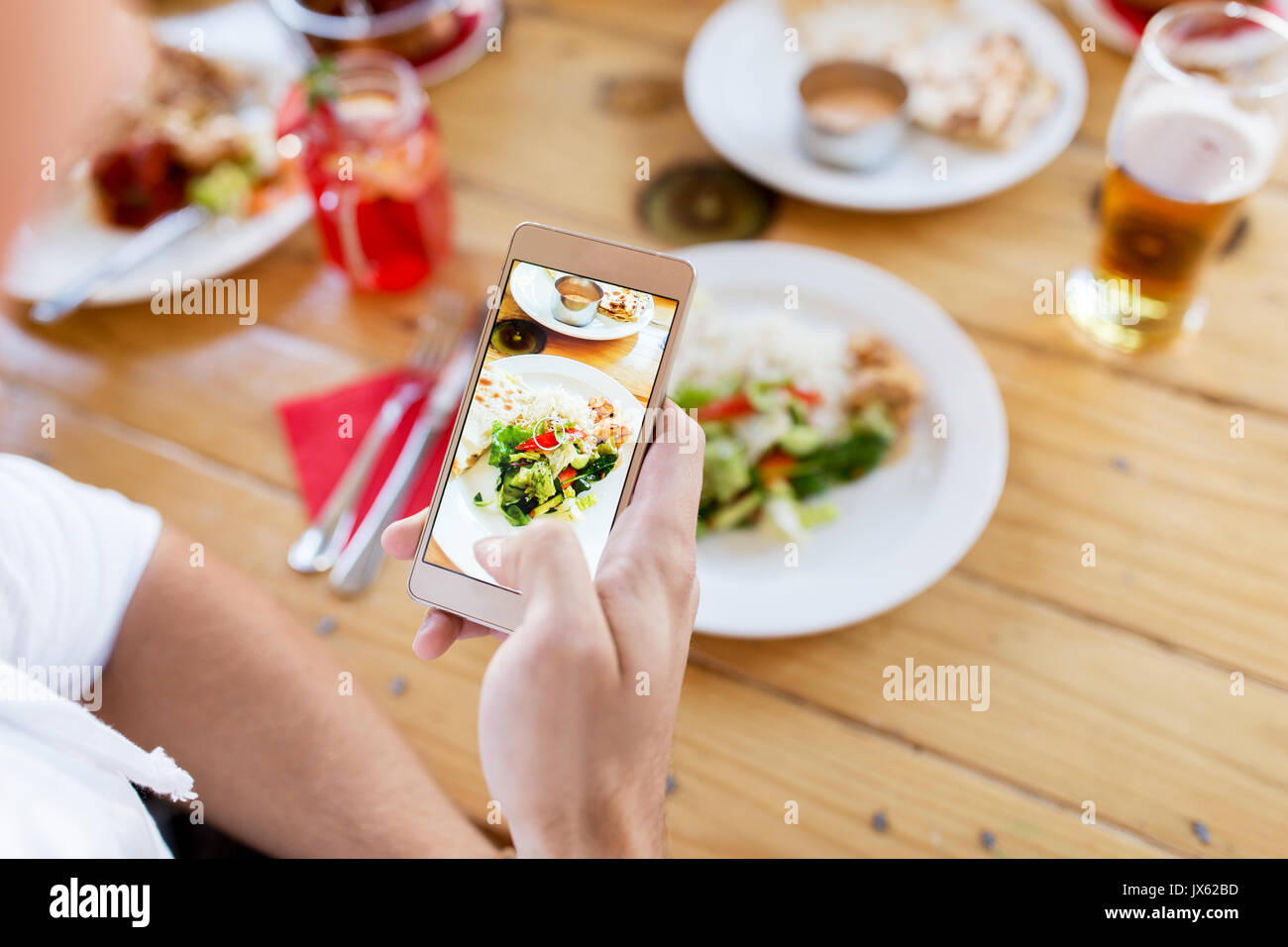 hand with smartphone picturing food at restaurant Stock Photo - Alamy