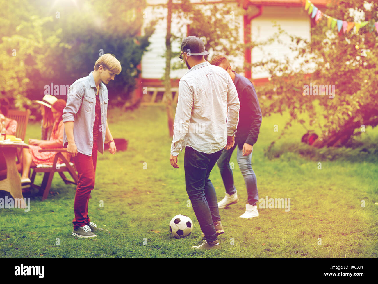 happy friends playing football at summer garden Stock Photo - Alamy