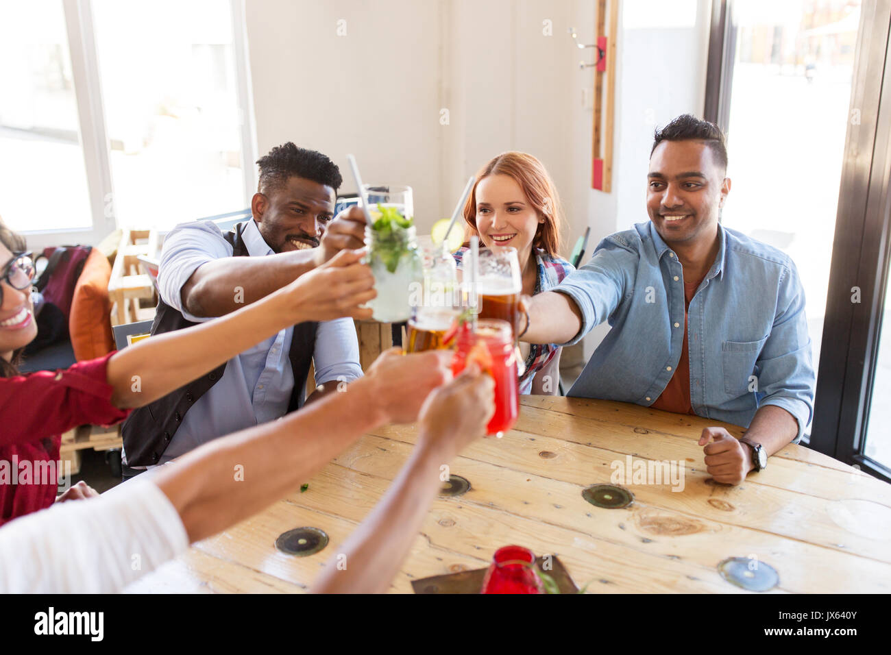 friends clinking glasses with drinks at restaurant Stock Photo - Alamy