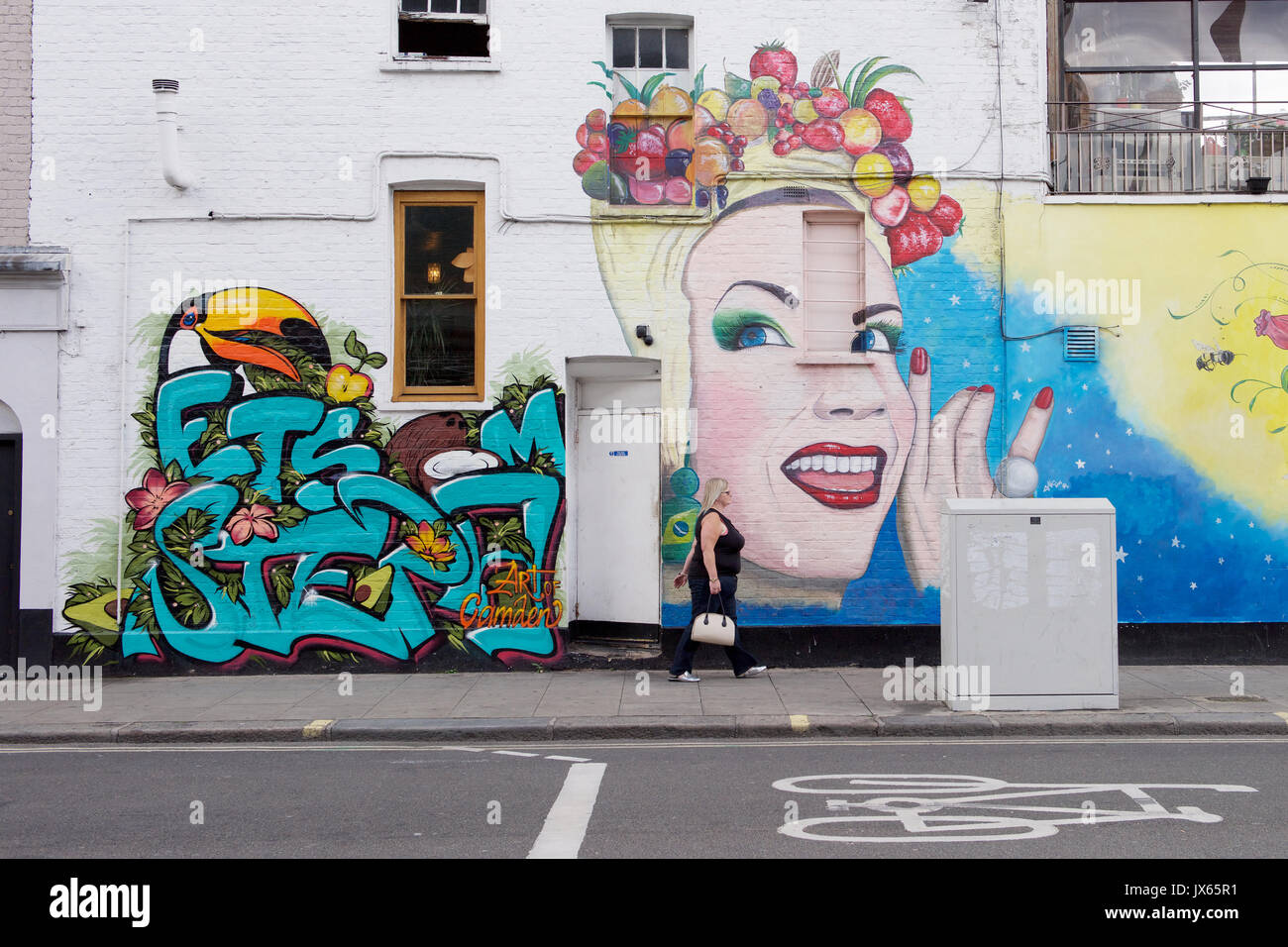 Woman walking past Graffiti artwork in Camden, London Stock Photo - Alamy