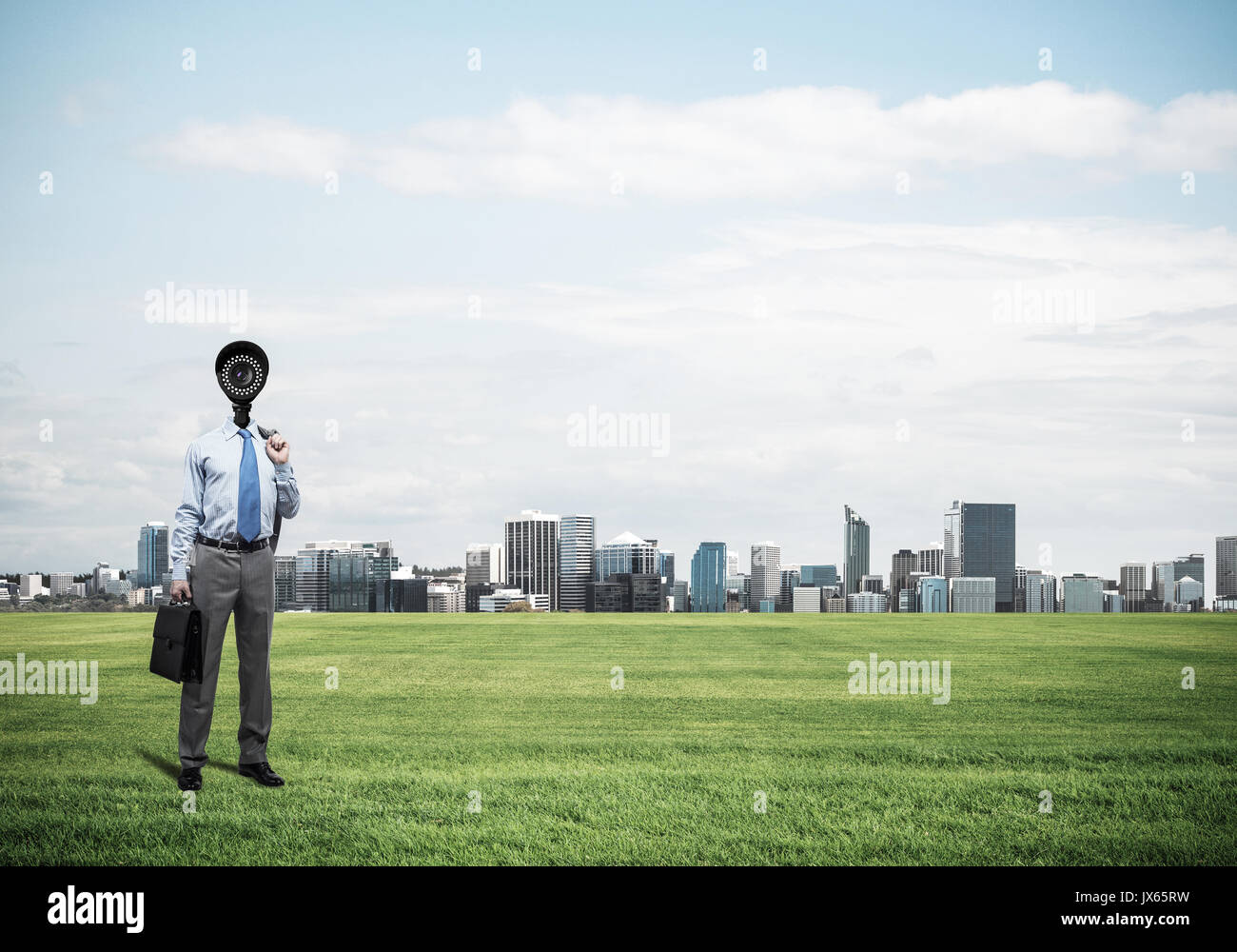Camera headed man standing on green grass against modern citysca Stock ...