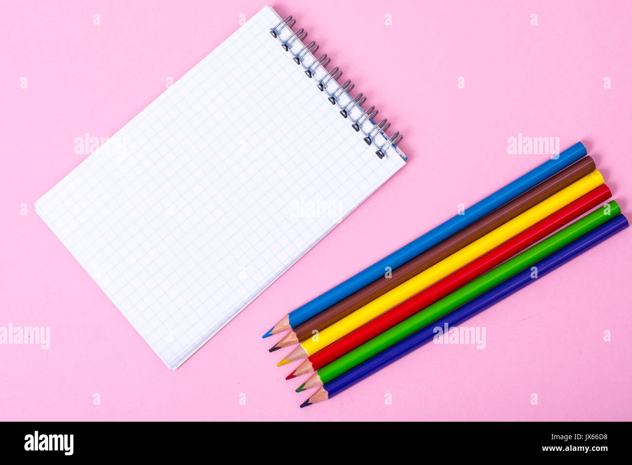 Notepad for notes and colorful pencils on colored background. Studio ...