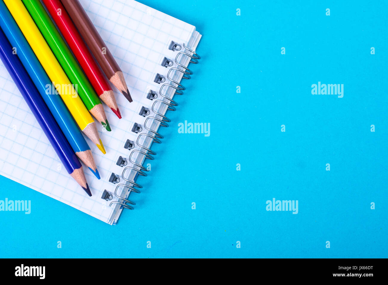 Notepad for notes and colorful pencils on colored background. Studio ...