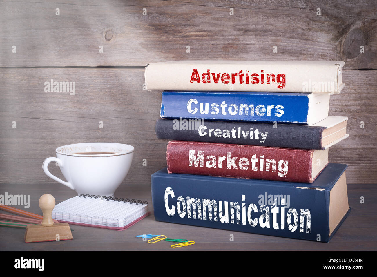 Advertising concept. Stack of books on wooden desk Stock Photo - Alamy