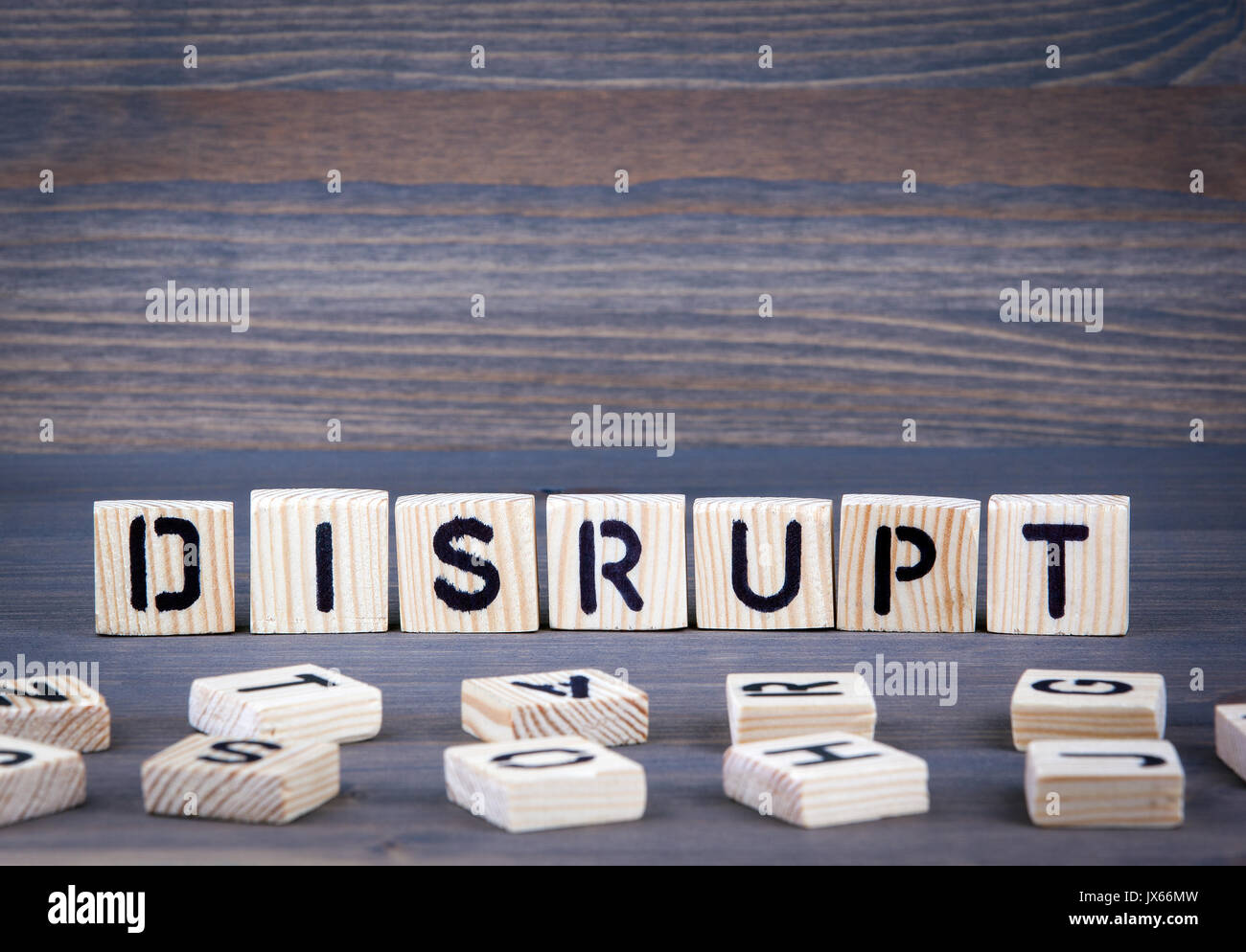 Disrupt word written on wood block. Dark wood background with texture ...