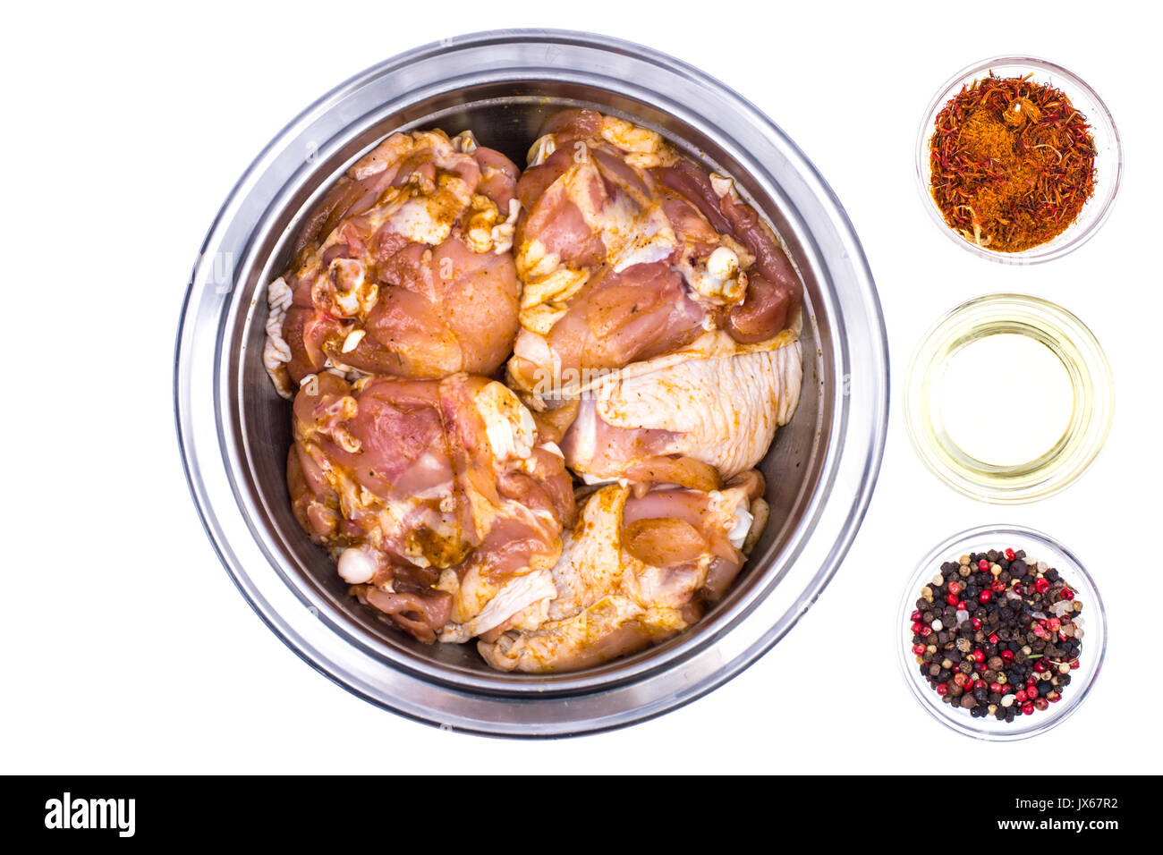 Pieces of raw chicken meat marinated with spices and olive oil on white ...