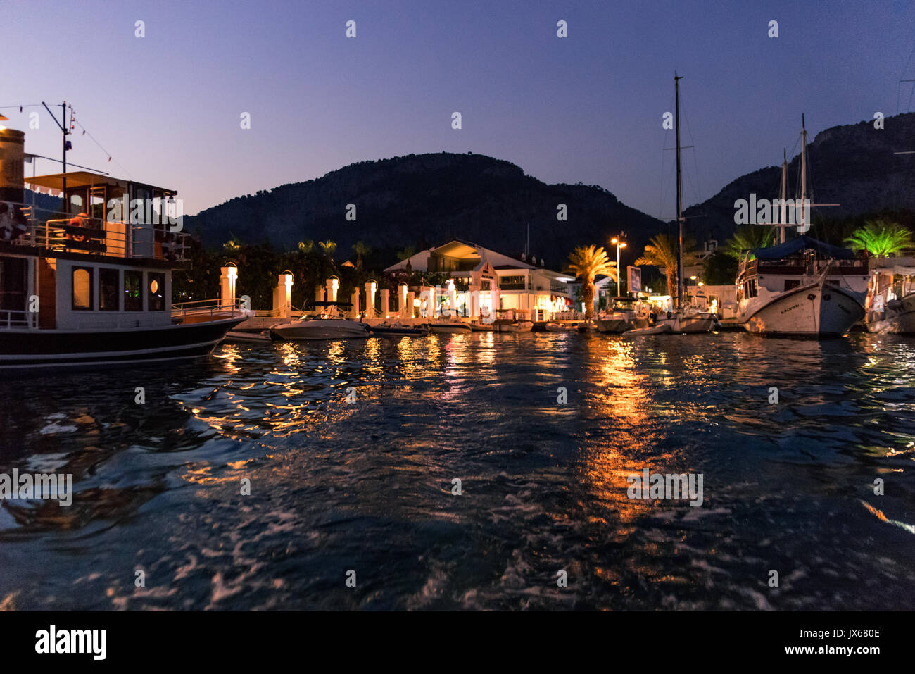 Small city and harbor at night. Sea and lights. Clear sky in Turkey ...