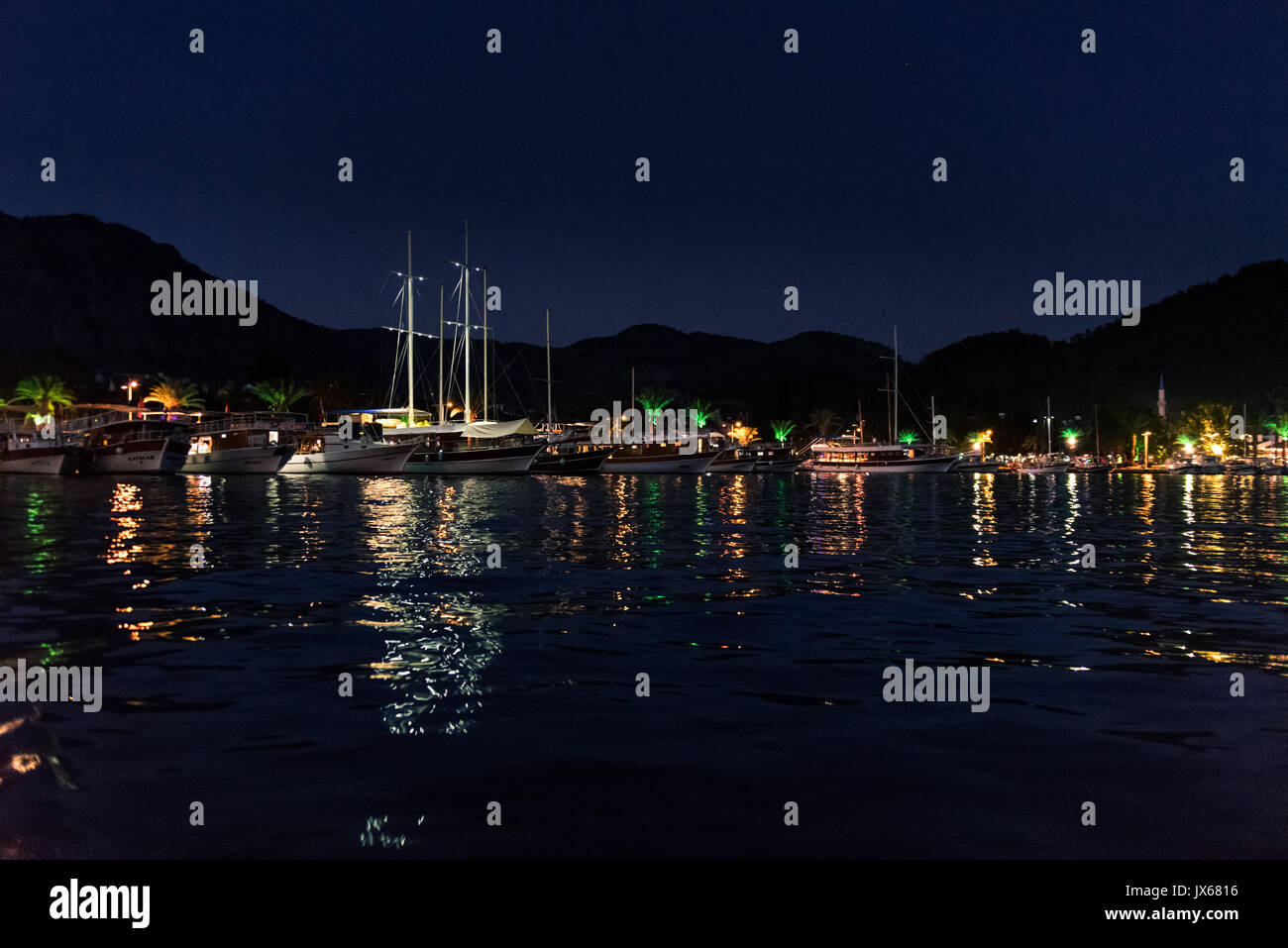 Small city and harbor at night. Sea and lights. Clear sky in Turkey ...