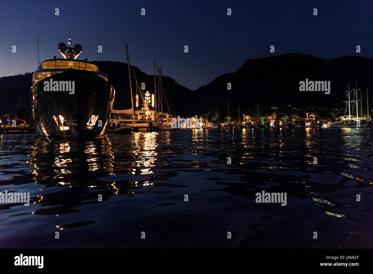 Small city and harbor at night. Sea and lights. Clear sky in Turkey ...