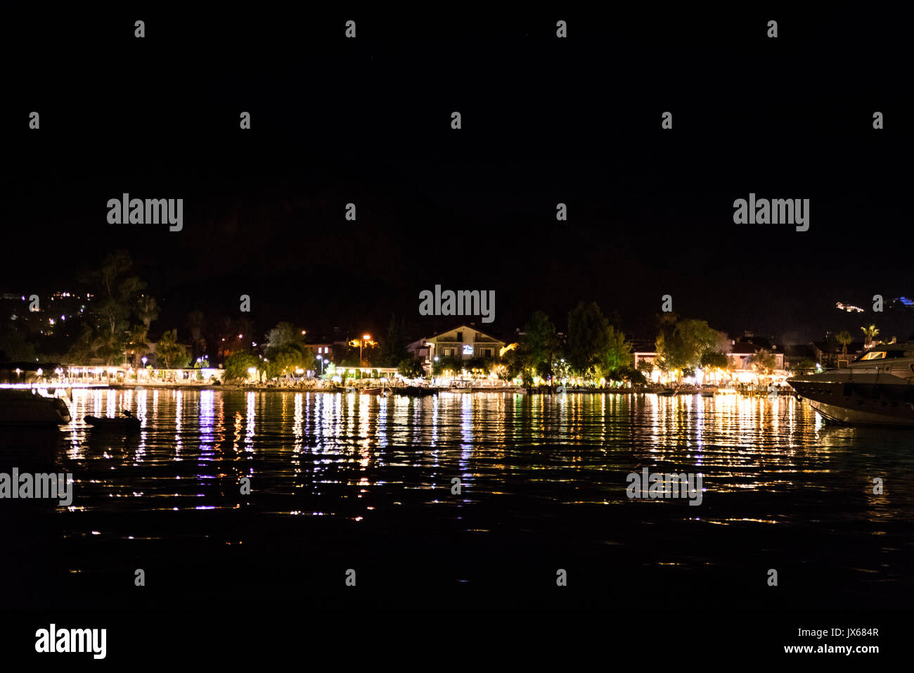Small city and harbor at night. Sea and lights. Clear sky in Turkey ...
