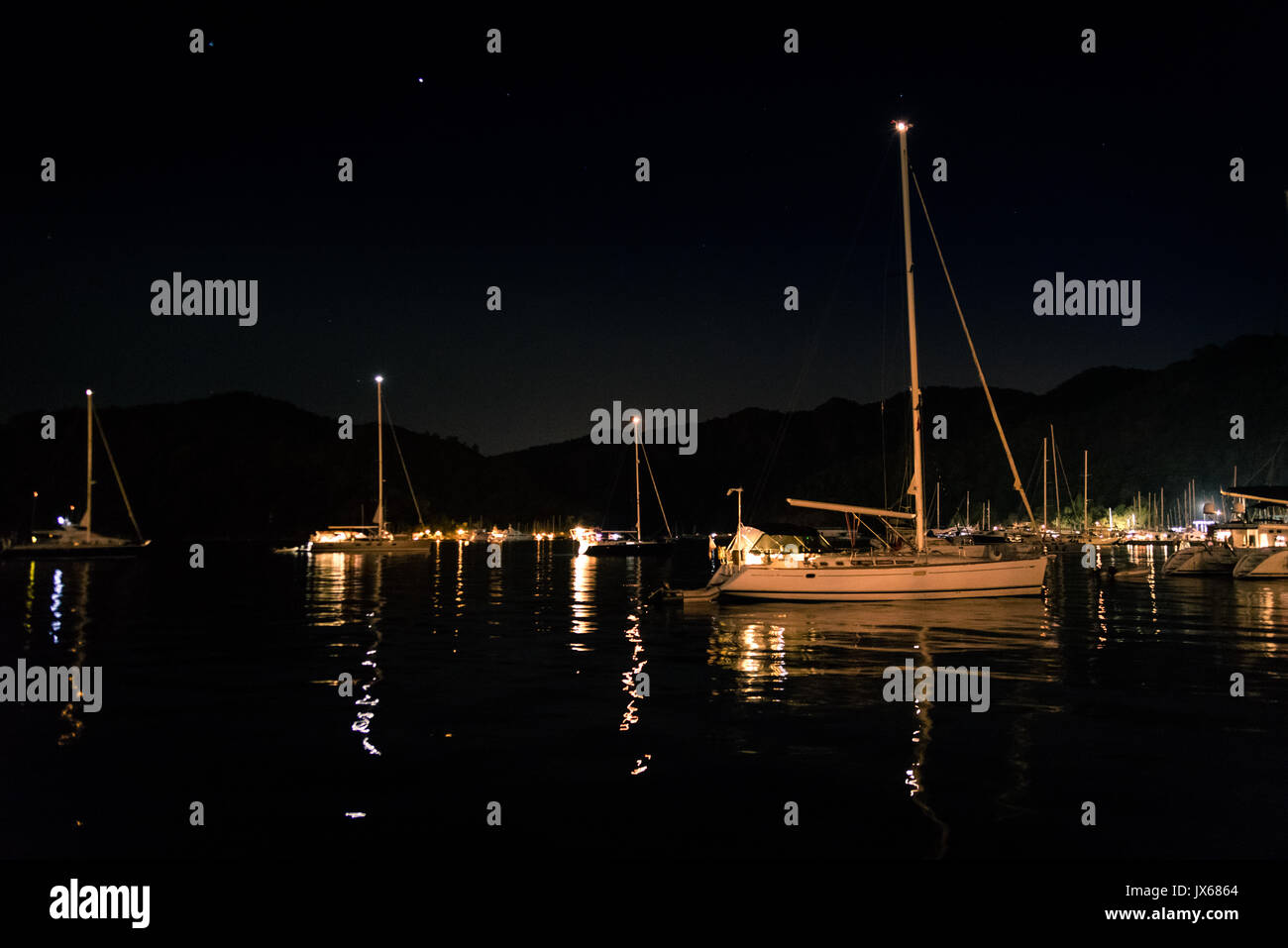 Small city and harbor at night. Sea and lights. Clear sky in Turkey ...