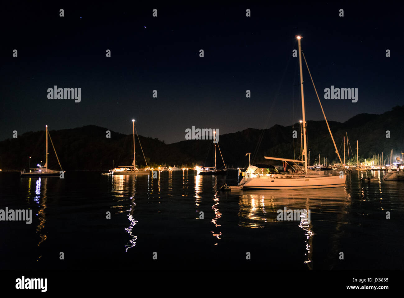 Small city and harbor at night. Sea and lights. Clear sky in Turkey ...