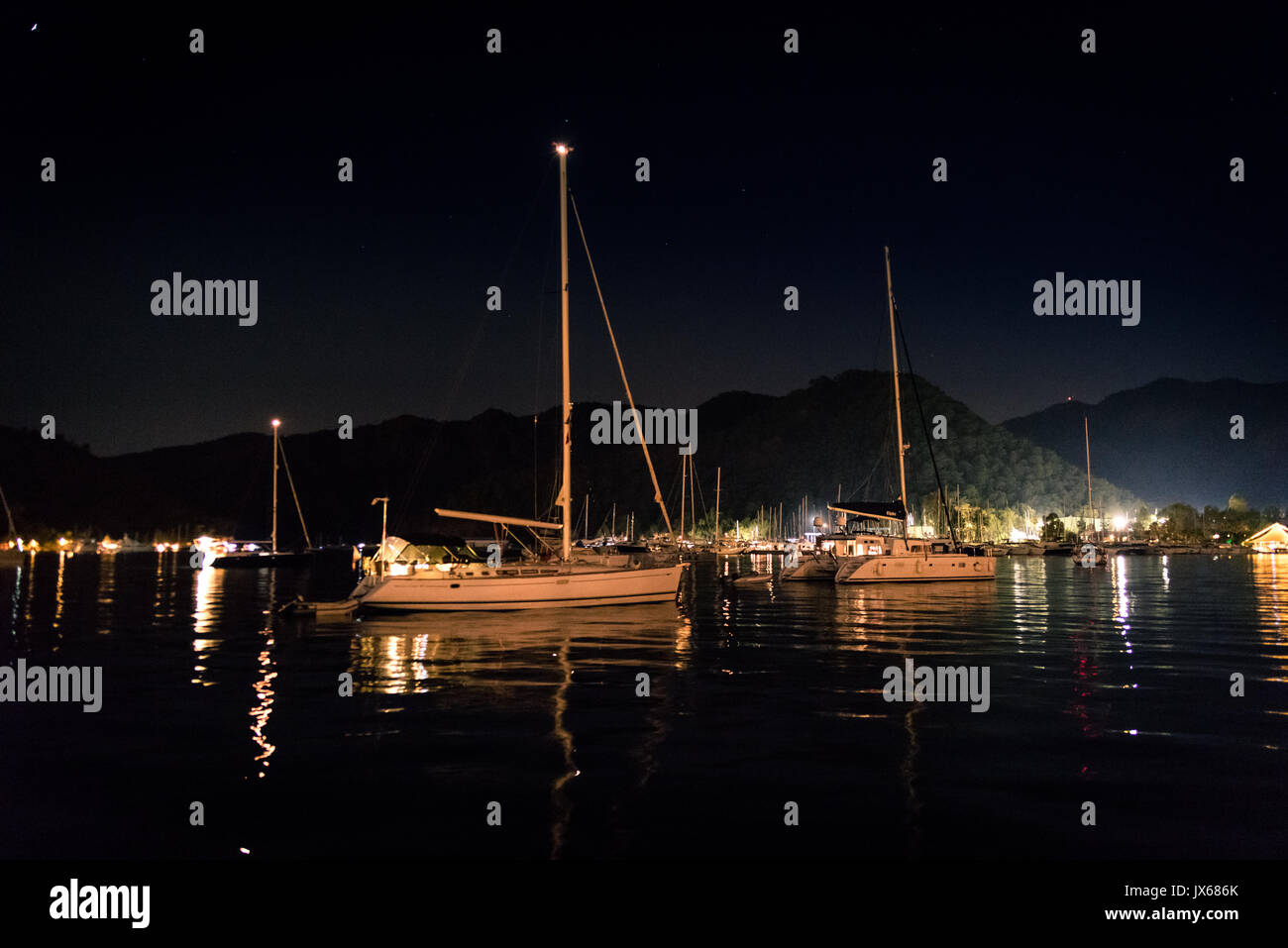 Small city and harbor at night. Sea and lights. Clear sky in Turkey ...