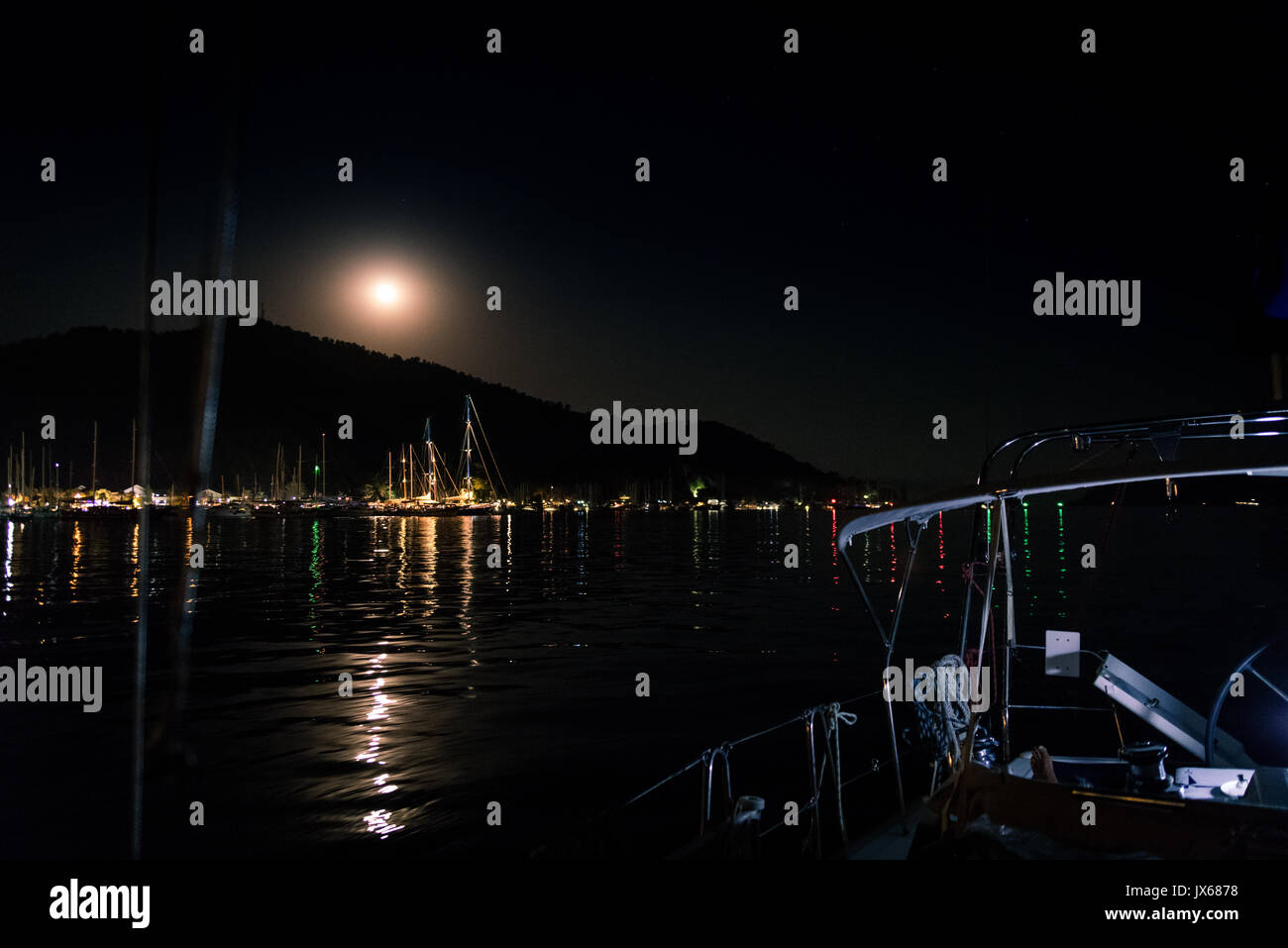 Small city and harbor at night. Sea and lights. Clear sky in Turkey ...
