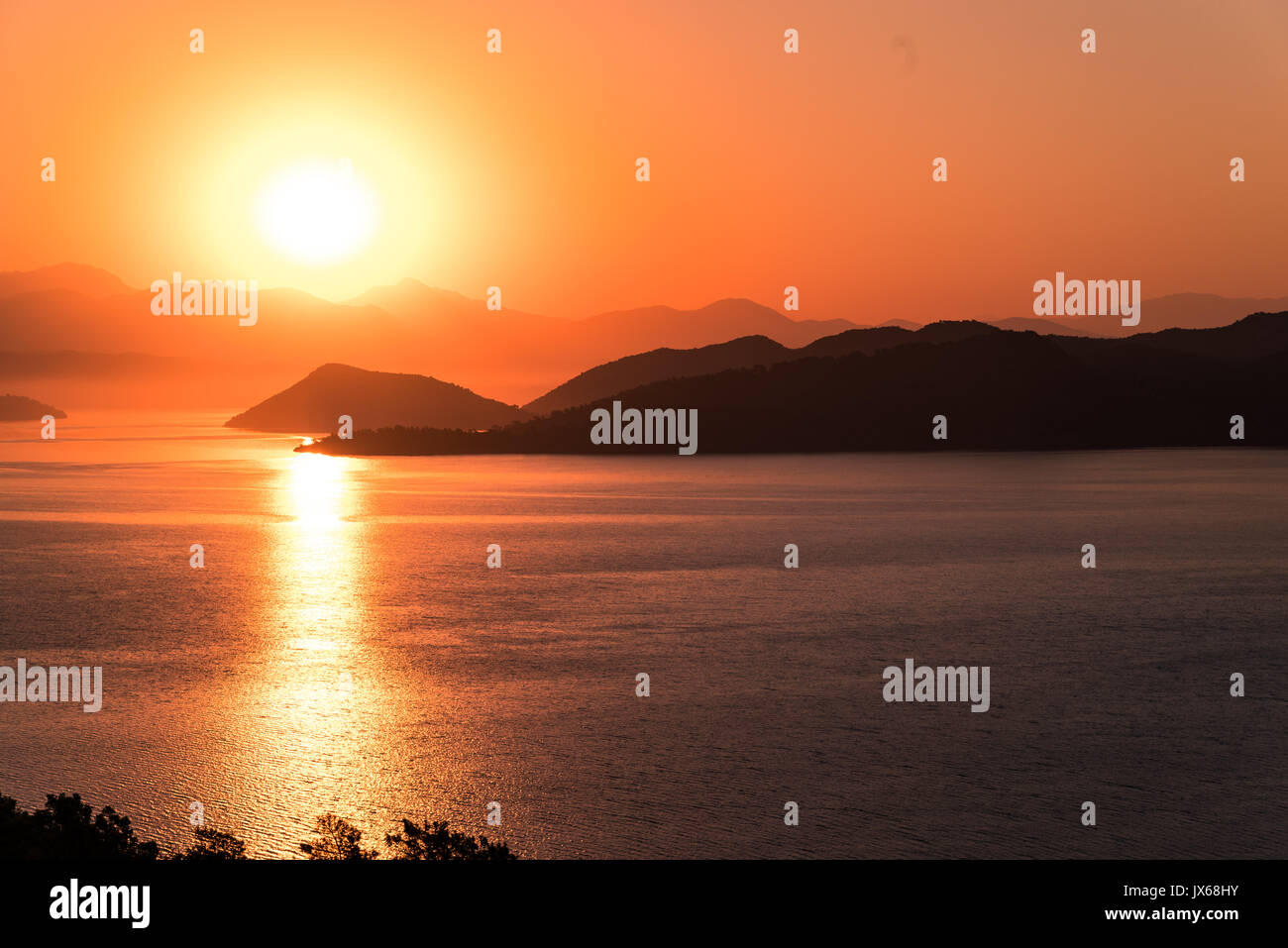 Sunrise over bay in Turkey with calm light and still water. Mountains ...