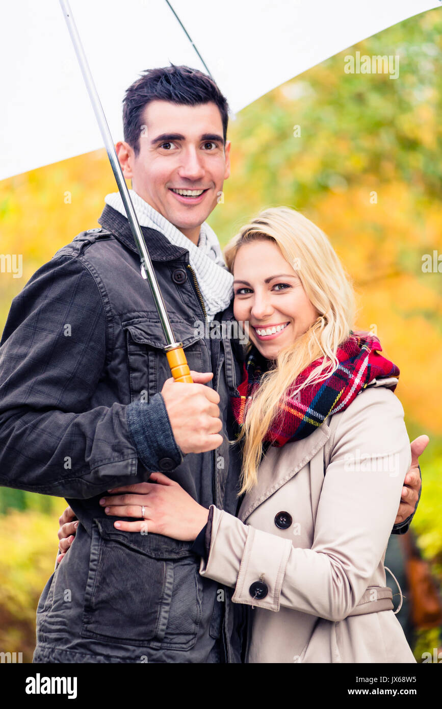 Couple enjoying fall day having walk despite the rain Stock Photo - Alamy