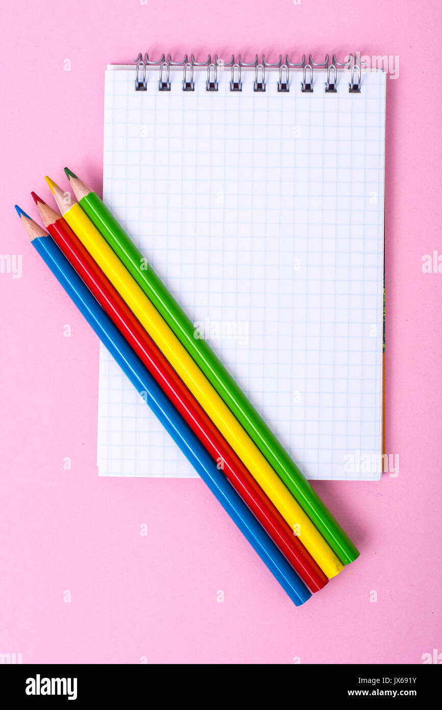 Notepad for notes and colorful pencils on colored background. Studio ...