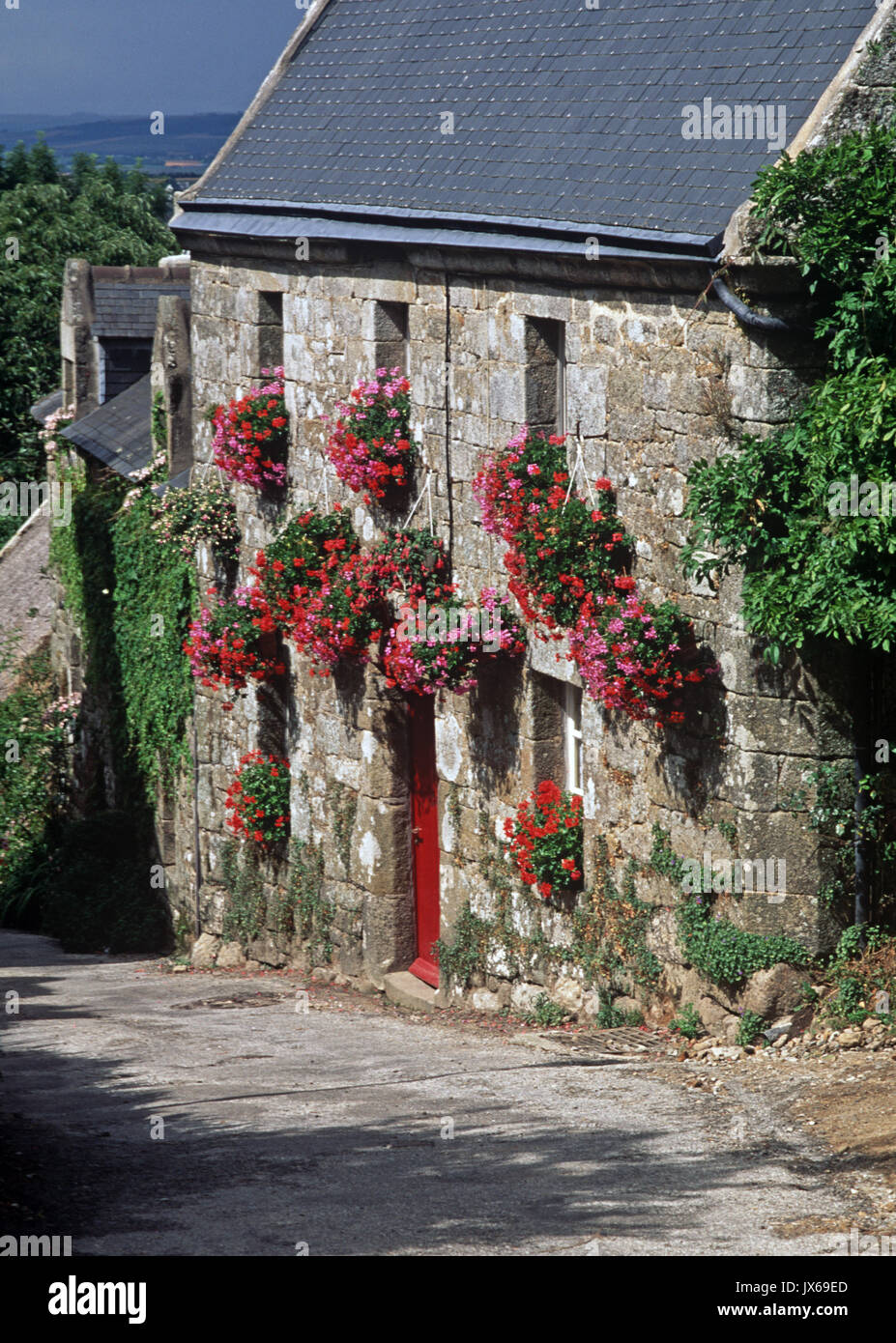 Flower covered window boxes on stone house in the village of Locronan, Finistere, Brittany ...
