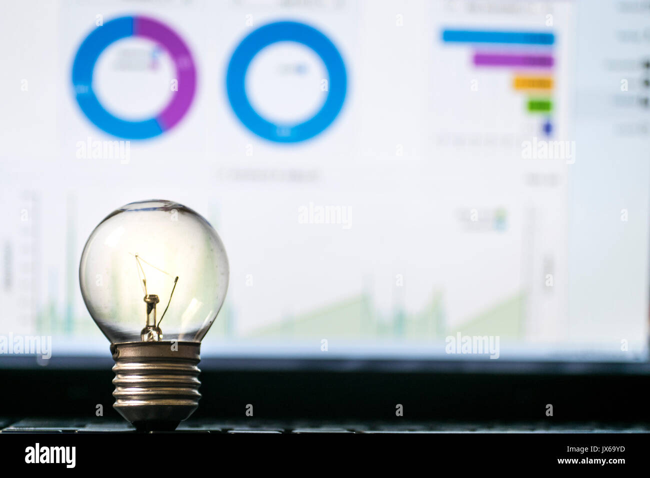 Standing lit light bulb on top of a laptop notebook computer black ...
