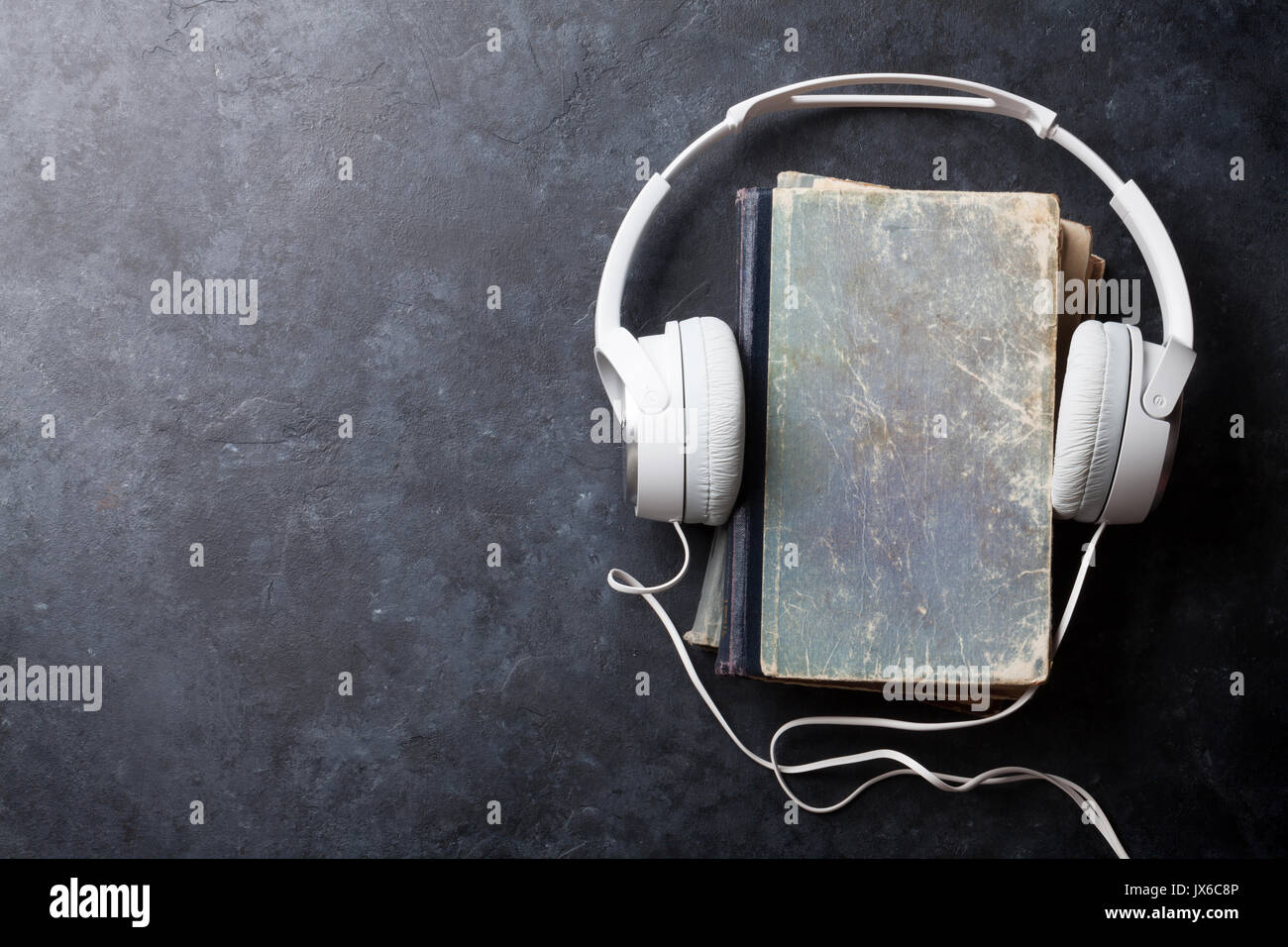 Audio book concept. Headphones and old books over stone table. Top view ...