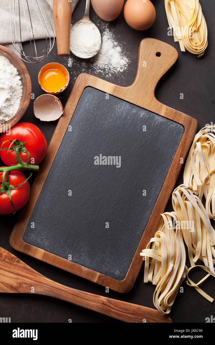 Pasta cooking ingredients on wooden kitchen table. Top view with ...
