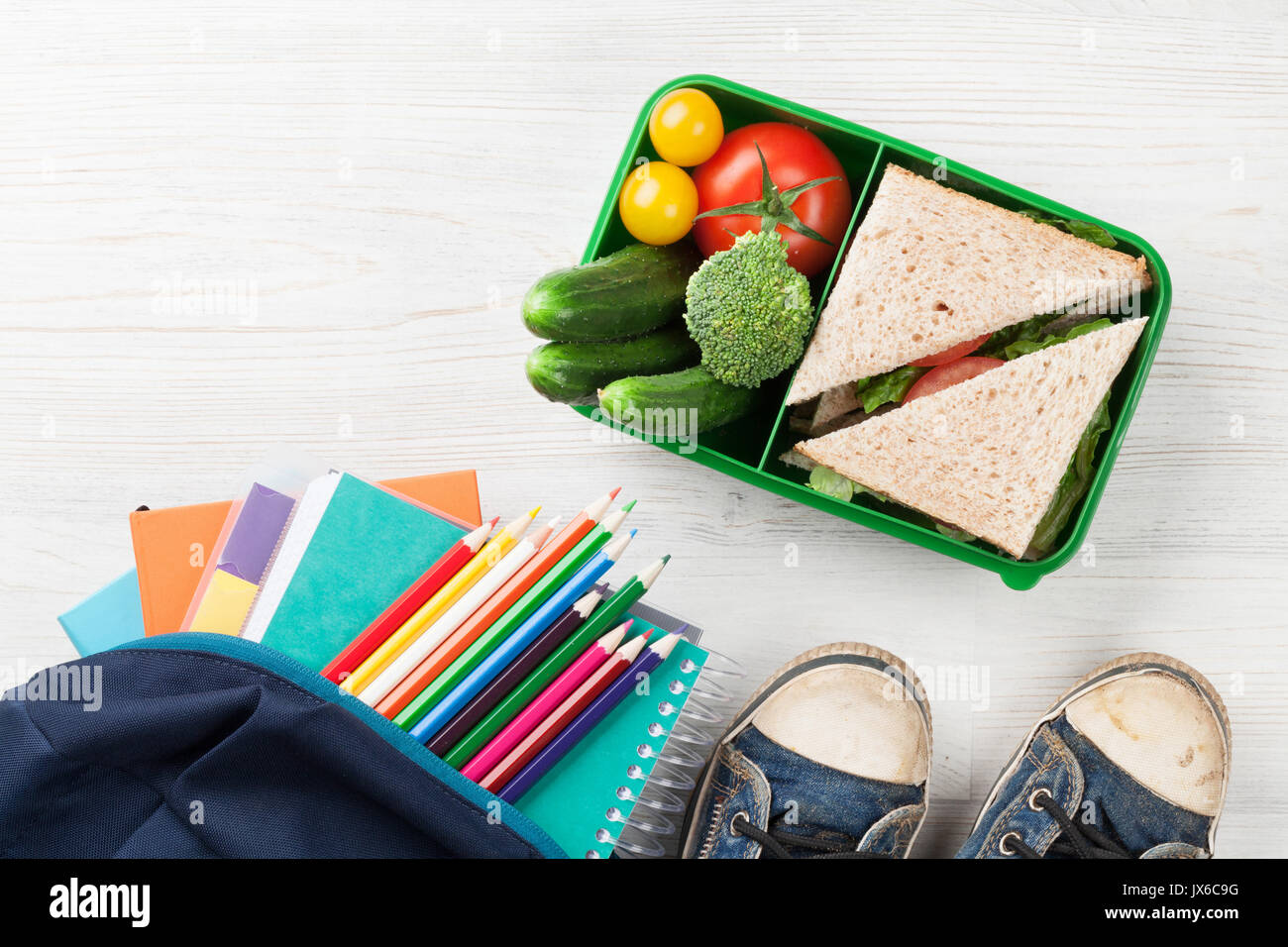 Lunch box with vegetables and sandwich on wooden table. Kids take away ...