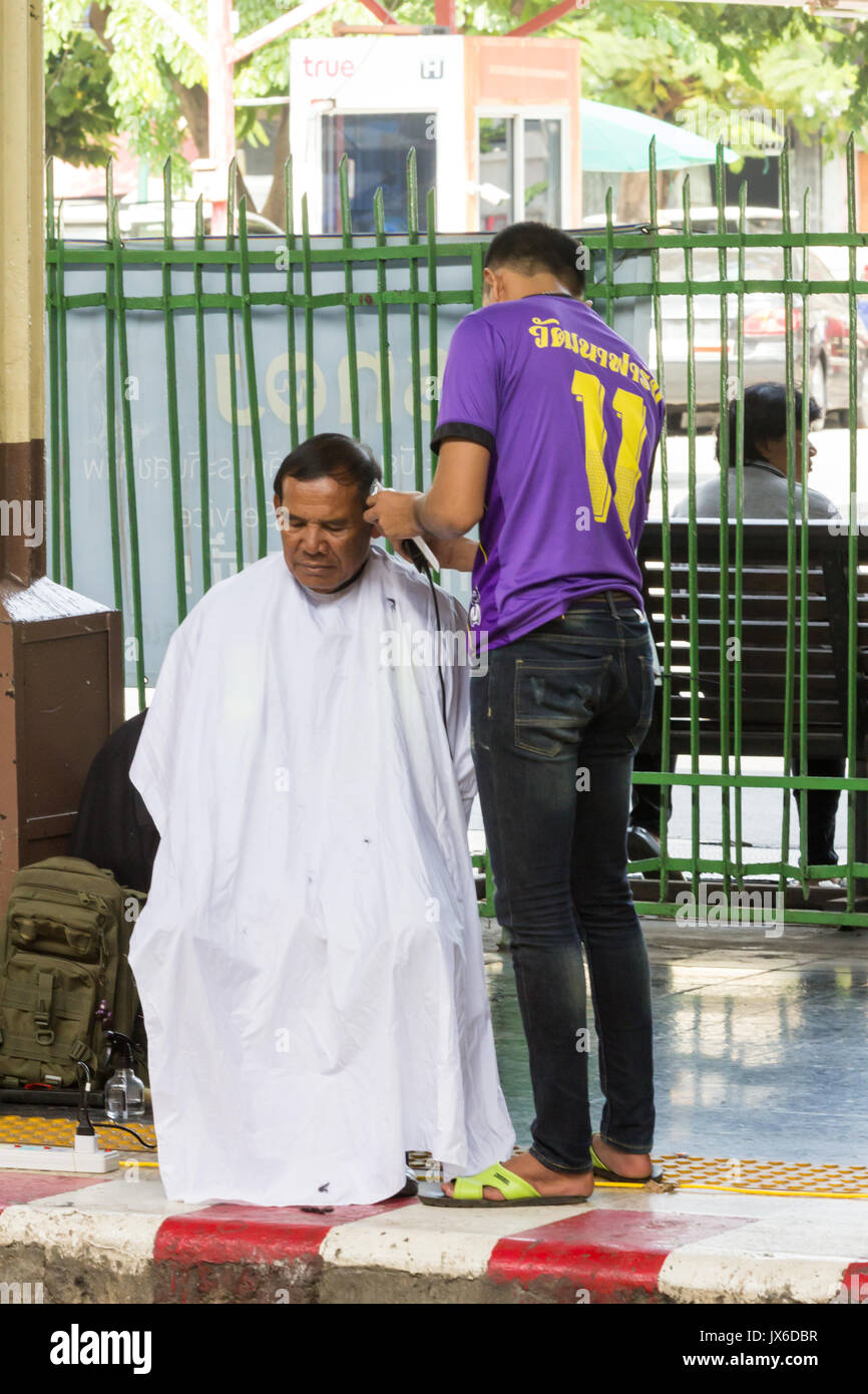 Man getting haircut from a barber on platform, Hua Lamphong station ...