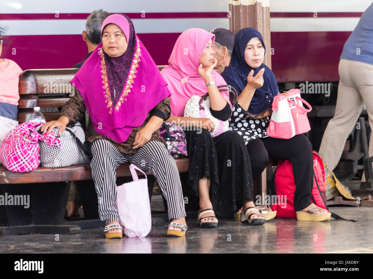 Muslim women sat on a platform bench waiting for a train, Hua Lamphong ...