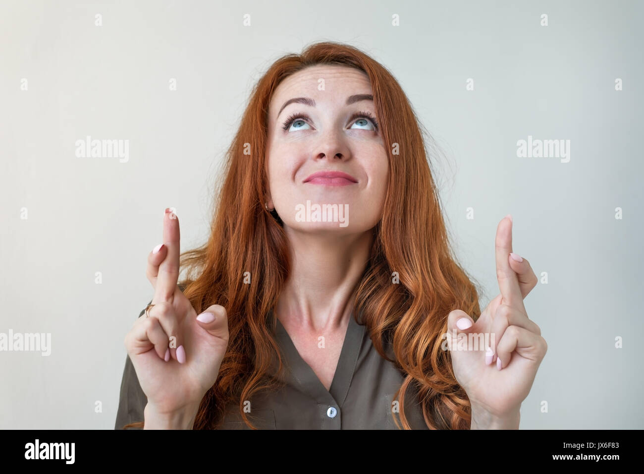 Body language. Superstitious caucasian woman with ginger hair and ...