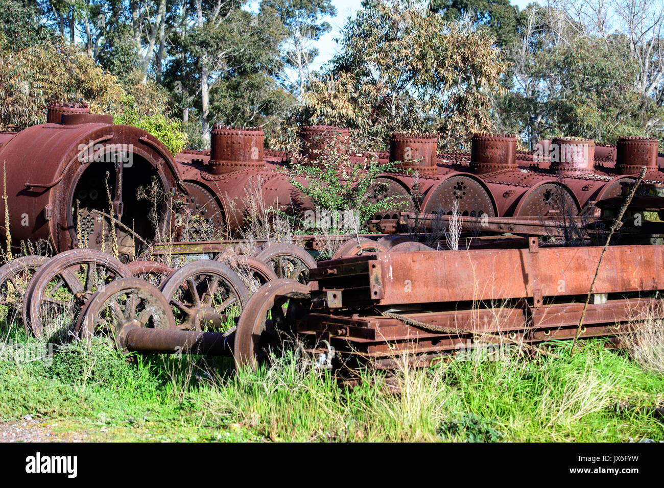 Old railway boilers and wheels lie rusting away in a railway graveyard ...