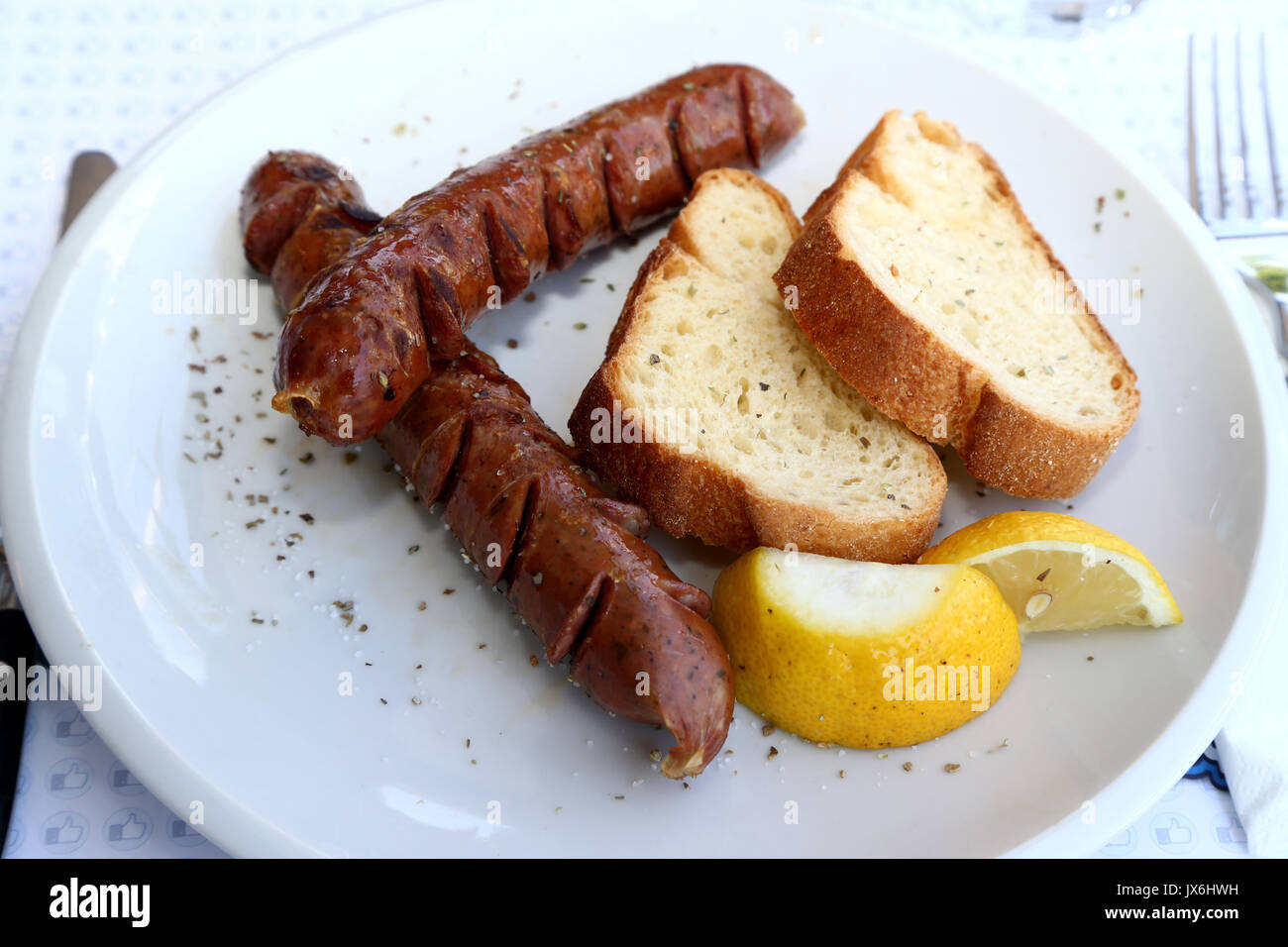 Greek sausages with lemon and bread Stock Photo - Alamy